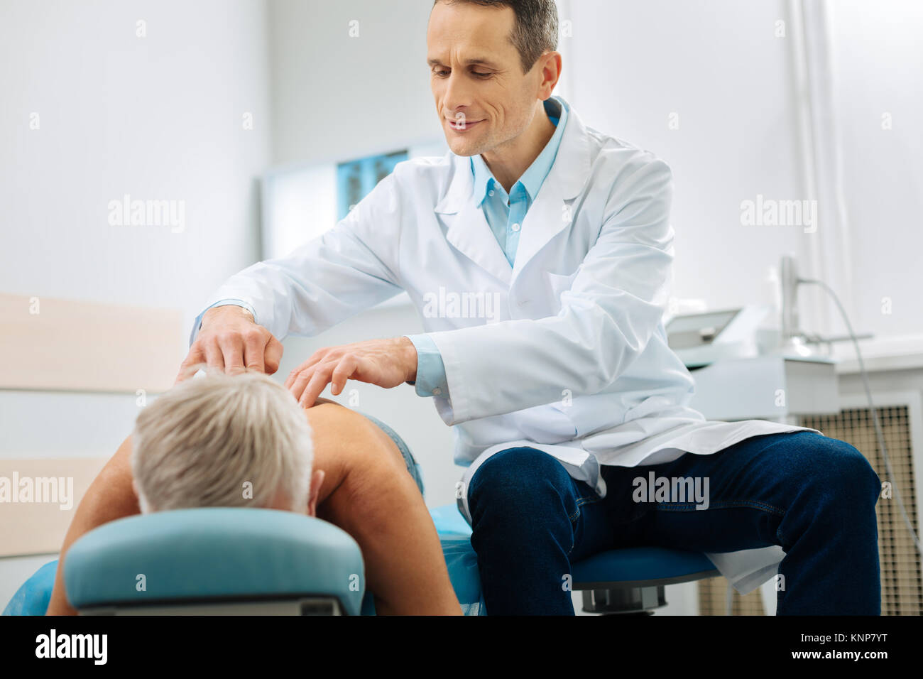 Nice professional doctor doing a massage Stock Photo - Alamy