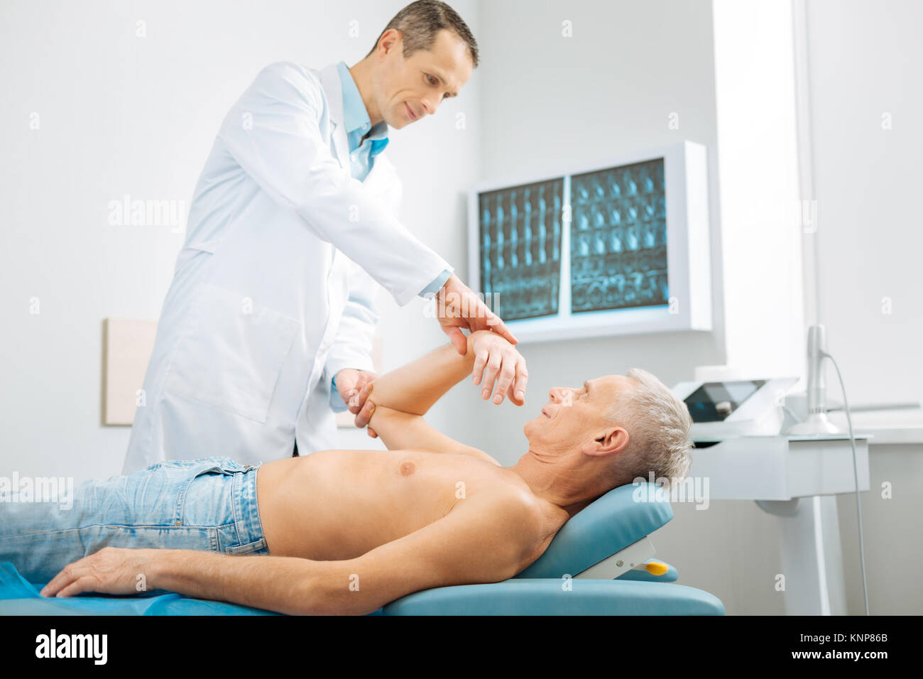 Nice serious doctor doing a checkup Stock Photo - Alamy