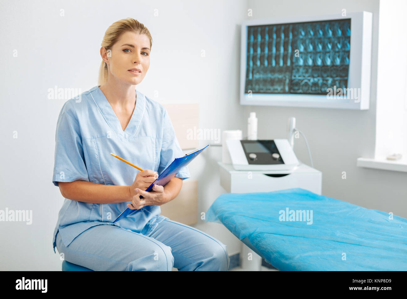 Pleasant smart doctor being ready to write Stock Photo - Alamy