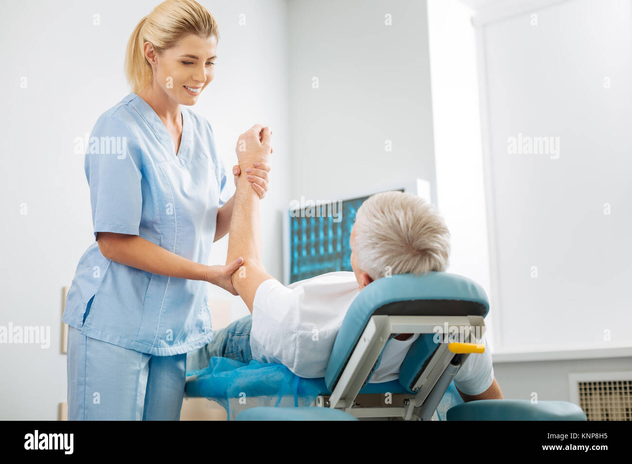 Positive female doctor holding her patients hand Stock Photo - Alamy