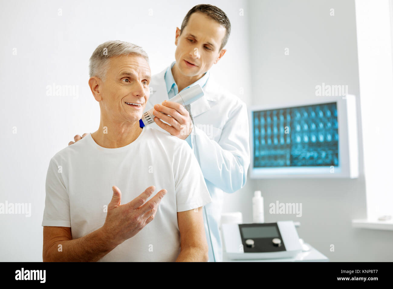 Smart handsome doctor using special scanning device Stock Photo - Alamy