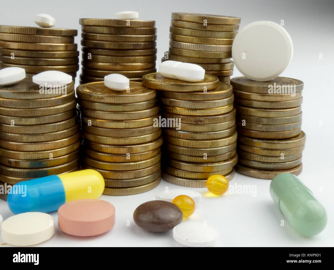 Pills and coins isolated on white background Stock Photo - Alamy