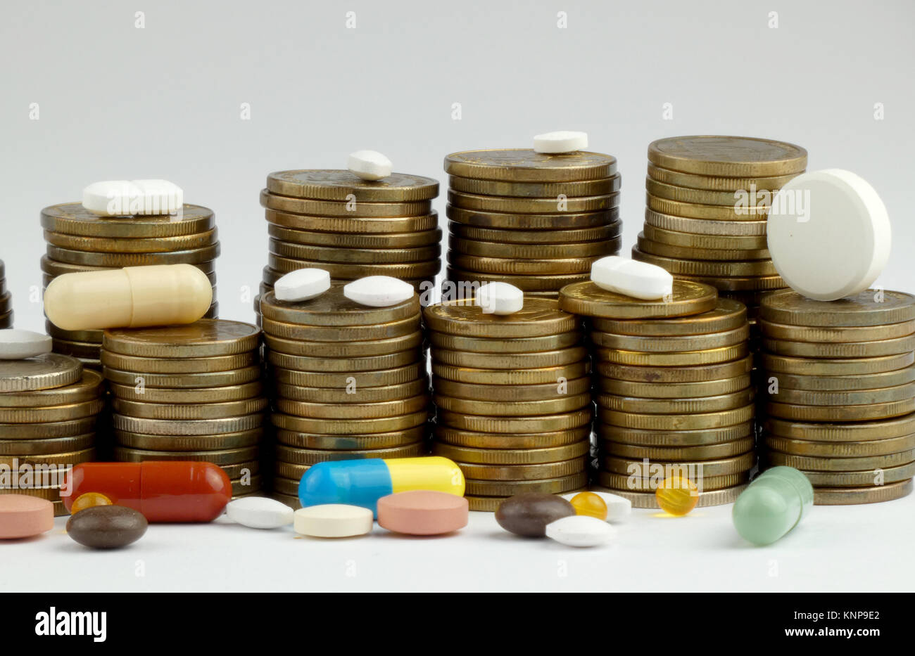 Pills and coins isolated on white background Stock Photo - Alamy
