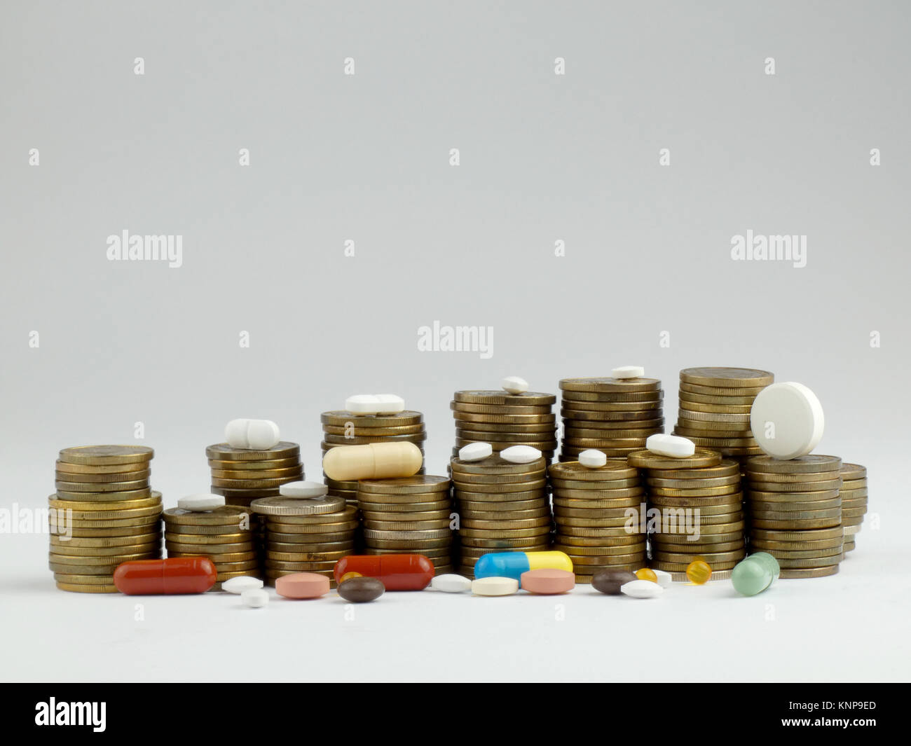 Pills and coins isolated on white background Stock Photo - Alamy
