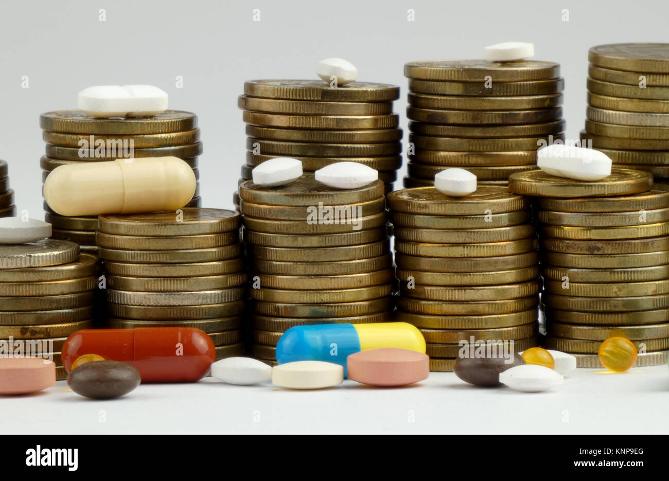 Pills and coins isolated on white background Stock Photo - Alamy