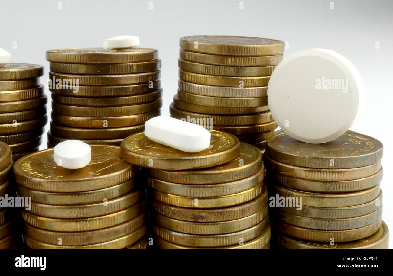 Pills and coins isolated on white background Stock Photo - Alamy