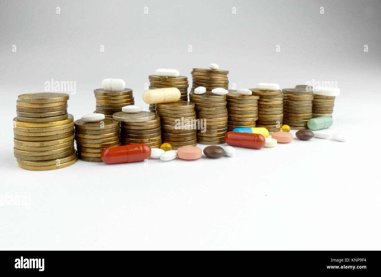 Pills and coins isolated on white background Stock Photo - Alamy
