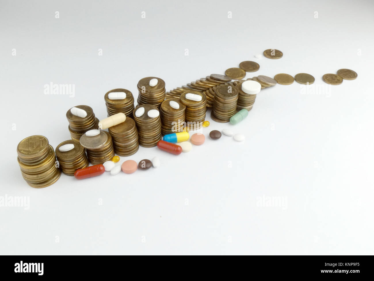 Pills and coins isolated on white background Stock Photo - Alamy