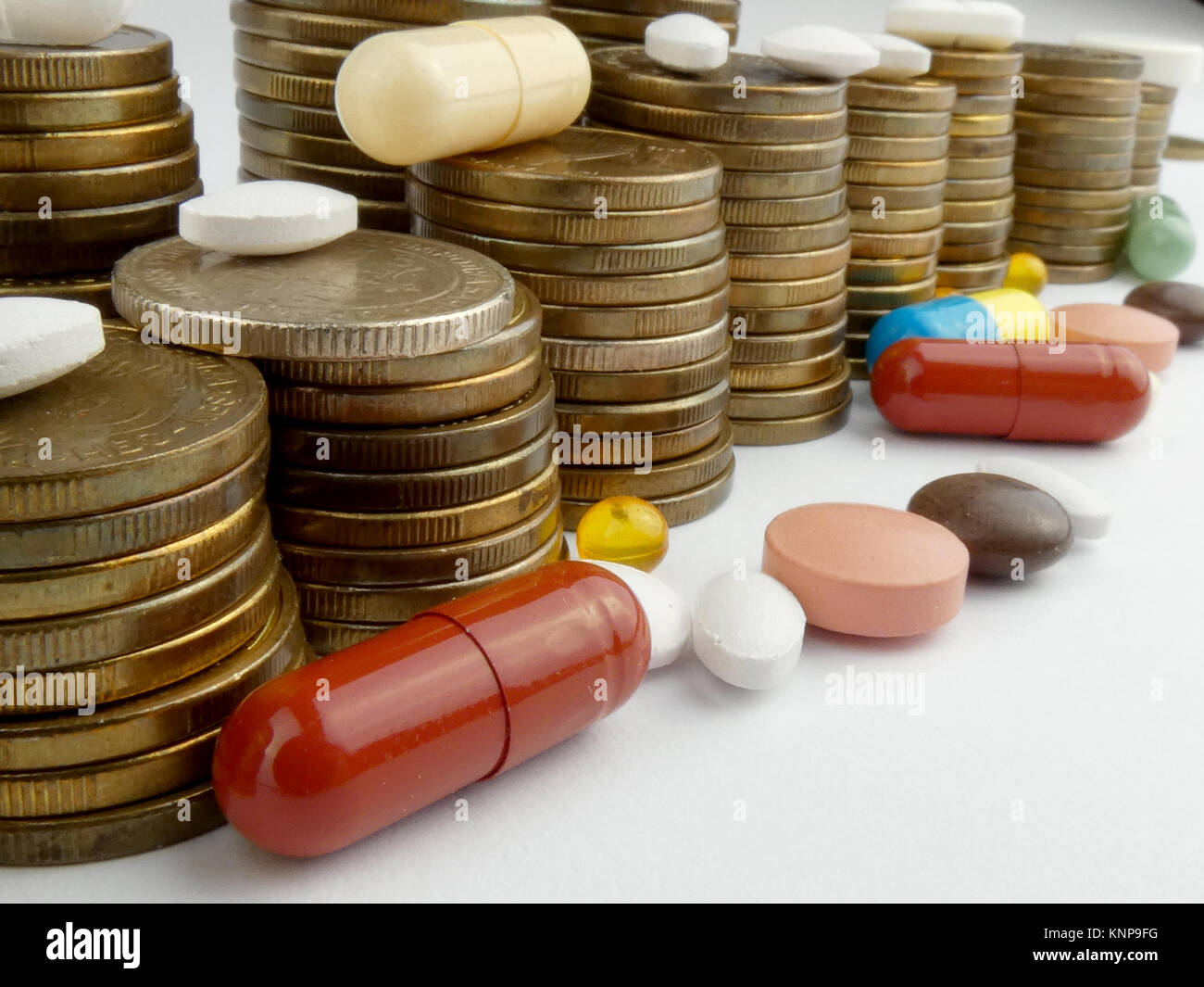 Pills and coins isolated on white background Stock Photo - Alamy