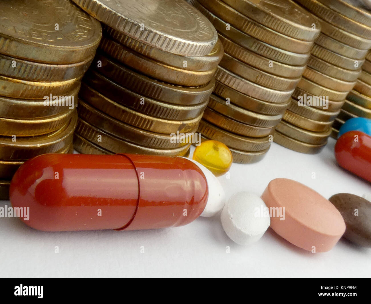 Pills and coins isolated on white background Stock Photo - Alamy