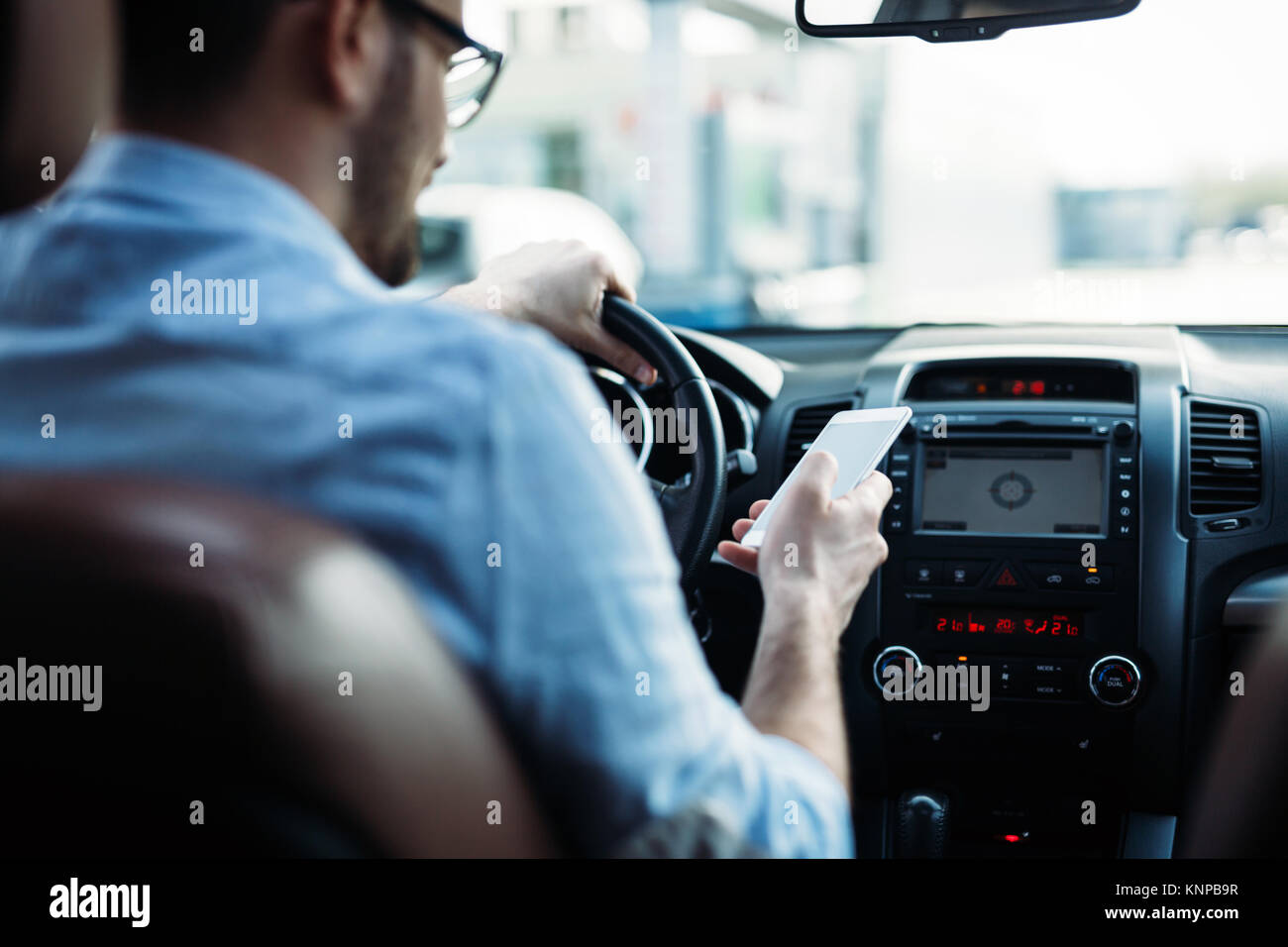 Man driver using smart phone on road in car Stock Photo - Alamy