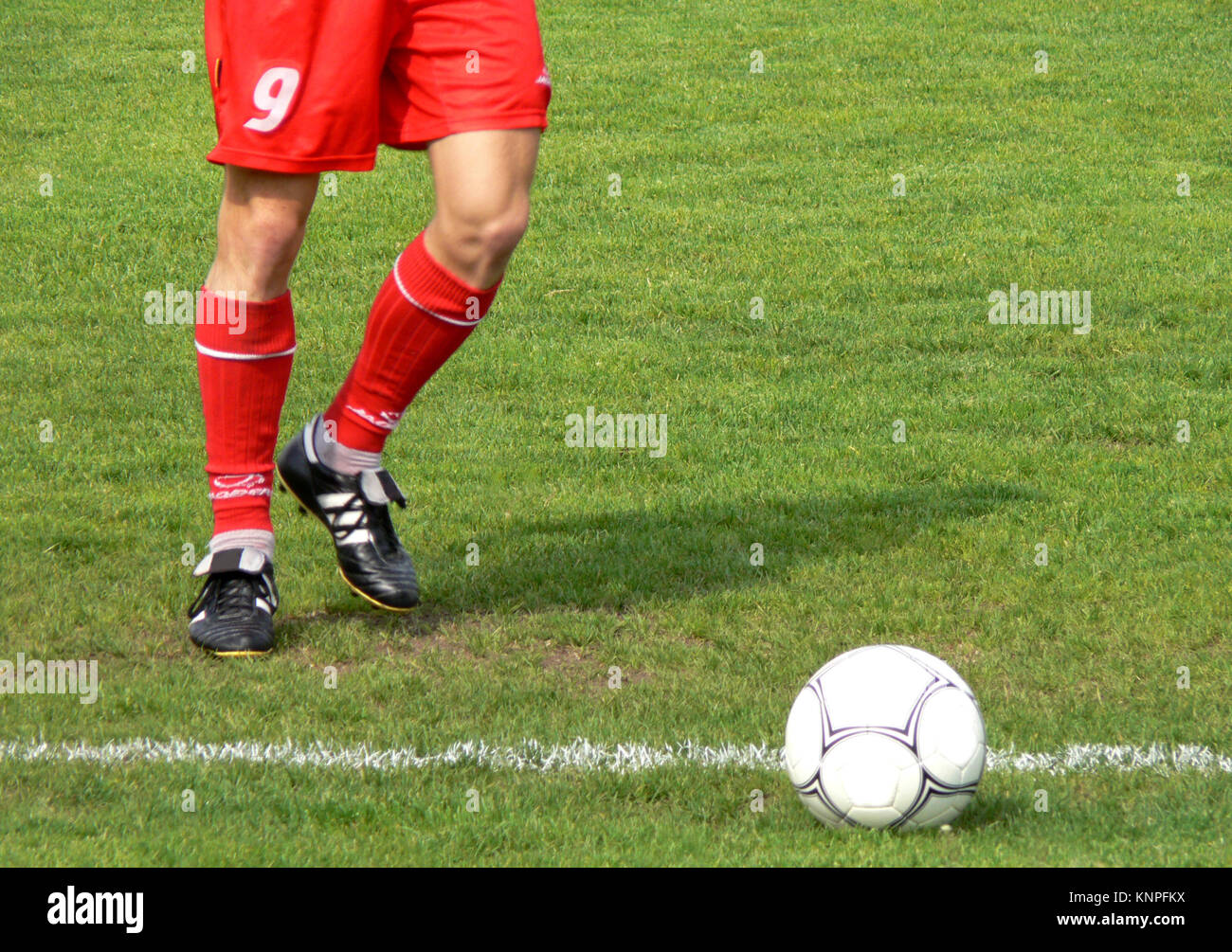 legs of a soccer player in red dress, in action during a game Stock ...