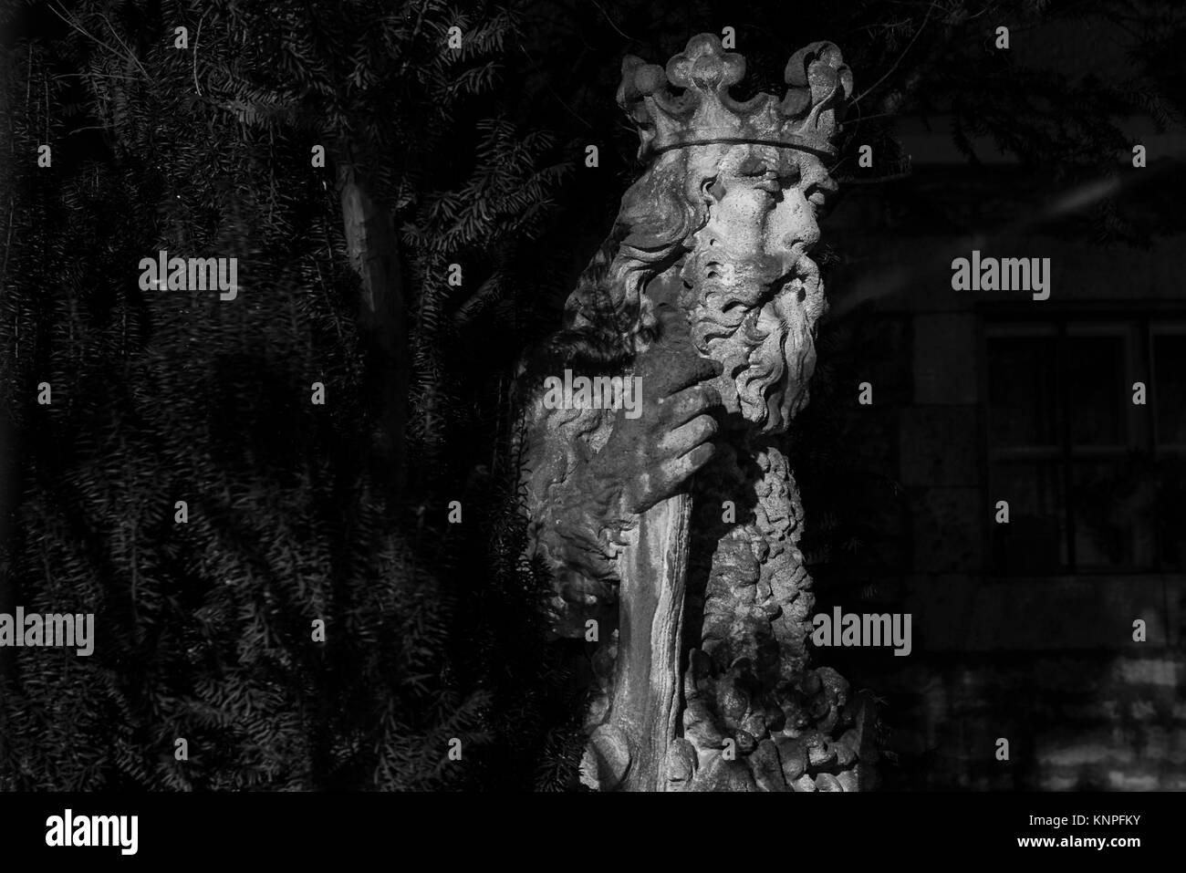 Old stone statue with crown and sword Stock Photo - Alamy