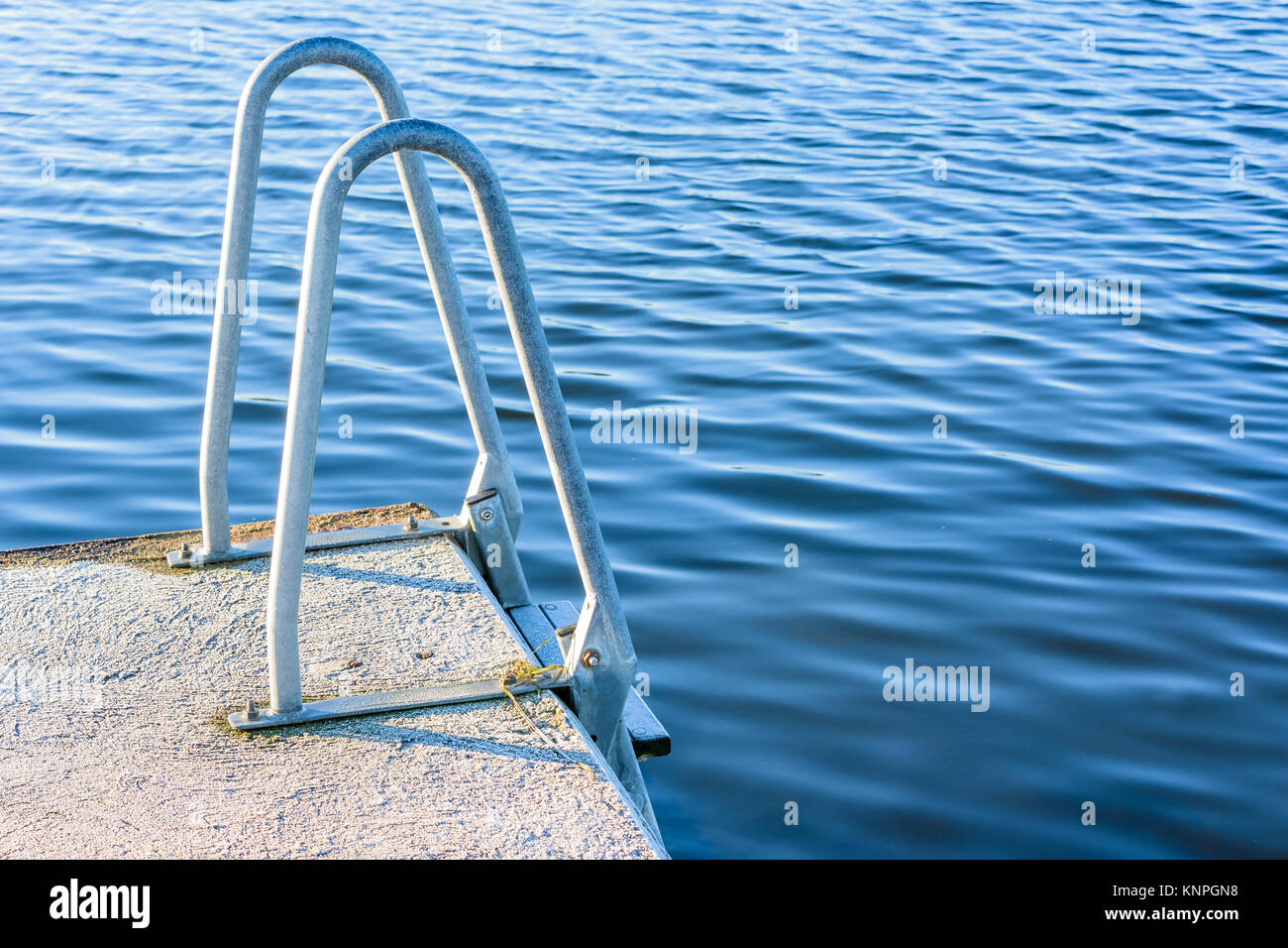 Bathing ladder at the end of a concrete pier Stock Photo - Alamy