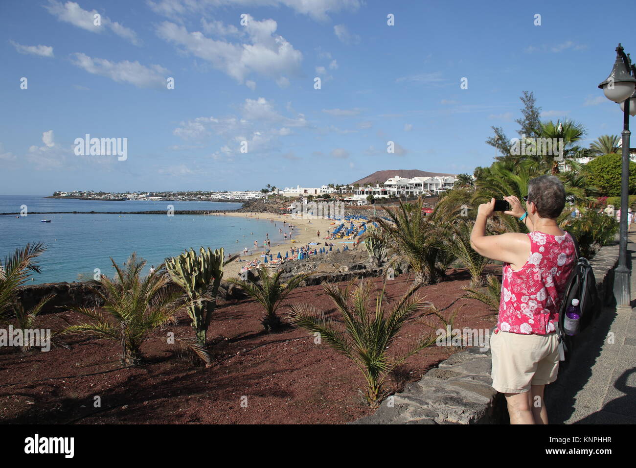 a female holidaymaker takes a picture across a scenic beach, Dorada at ...