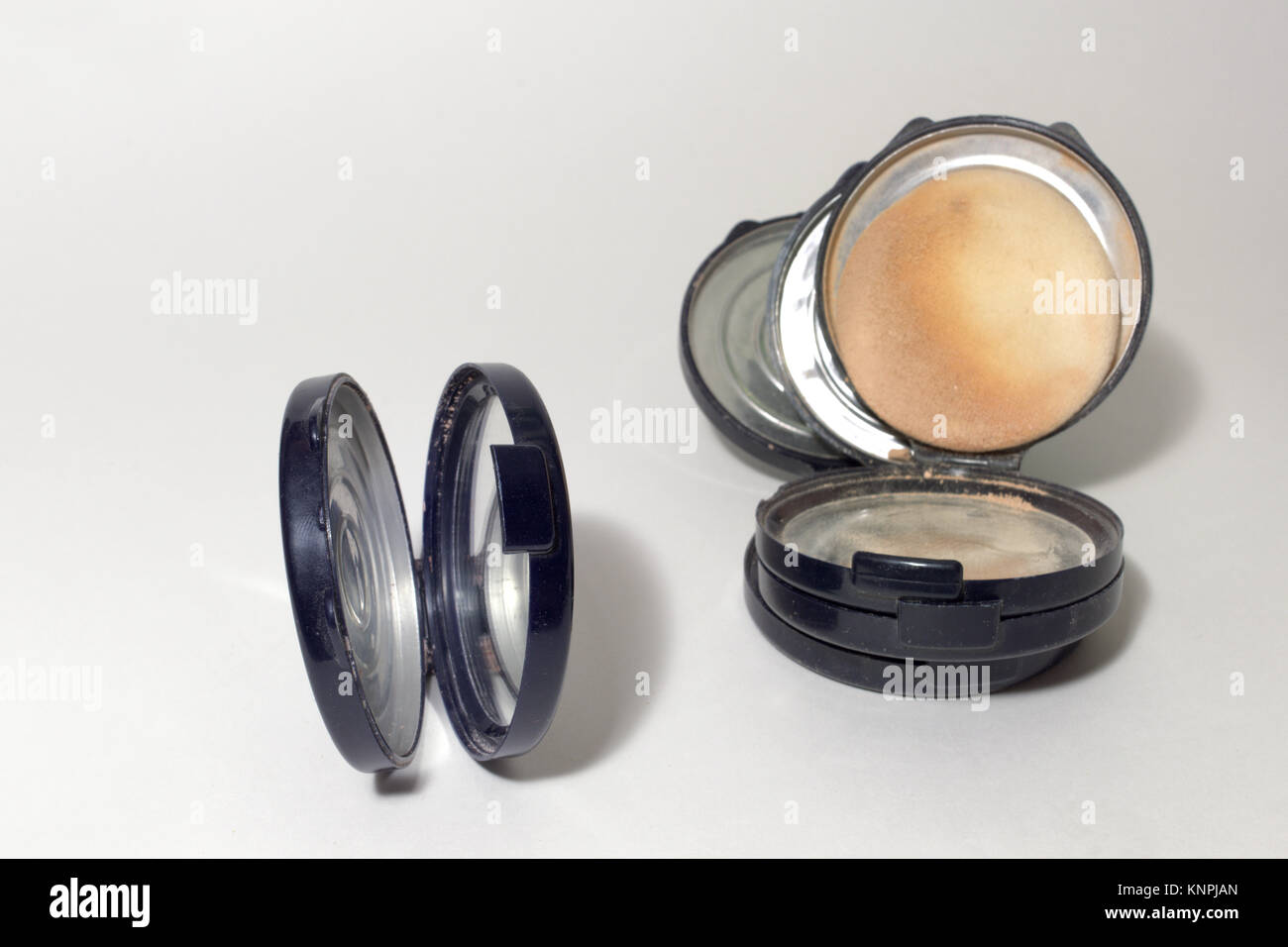 empty powder cases, lying on each other, used powderpuff and one case ...