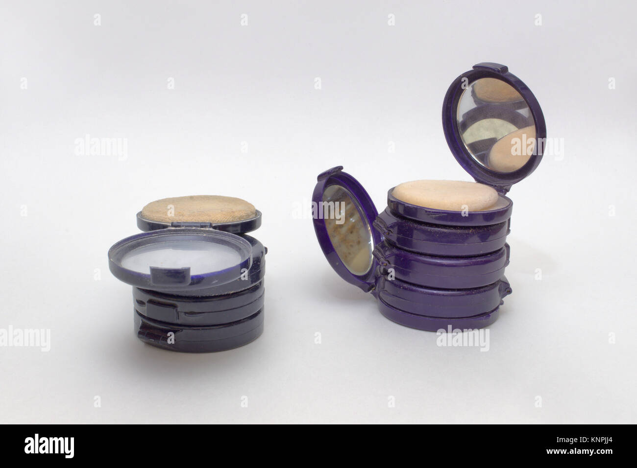 compact powder boxes in vertical stacks, open cases contains mirror and ...