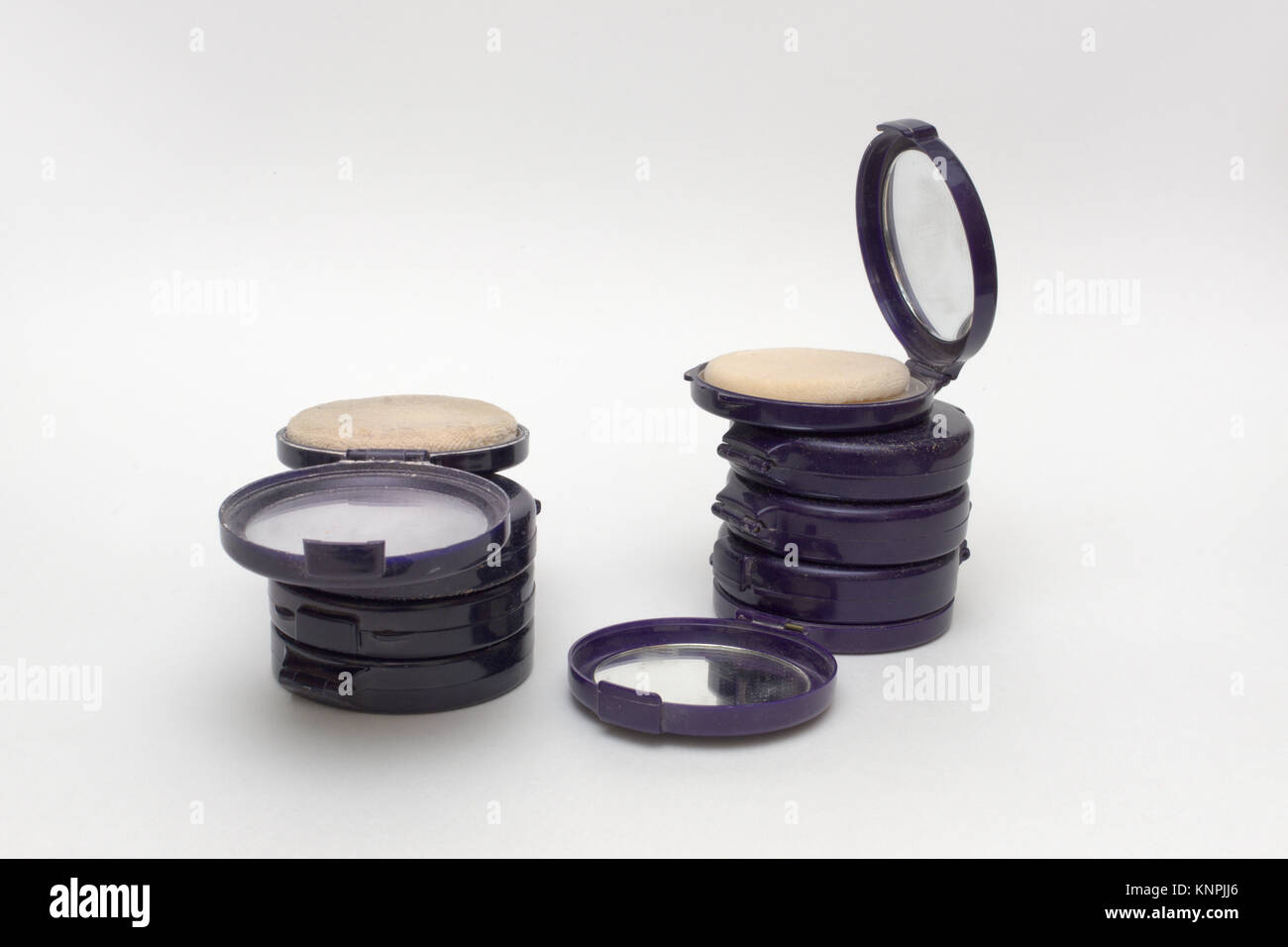 compact powder boxes in vertical stacks, open cases contains glued ...