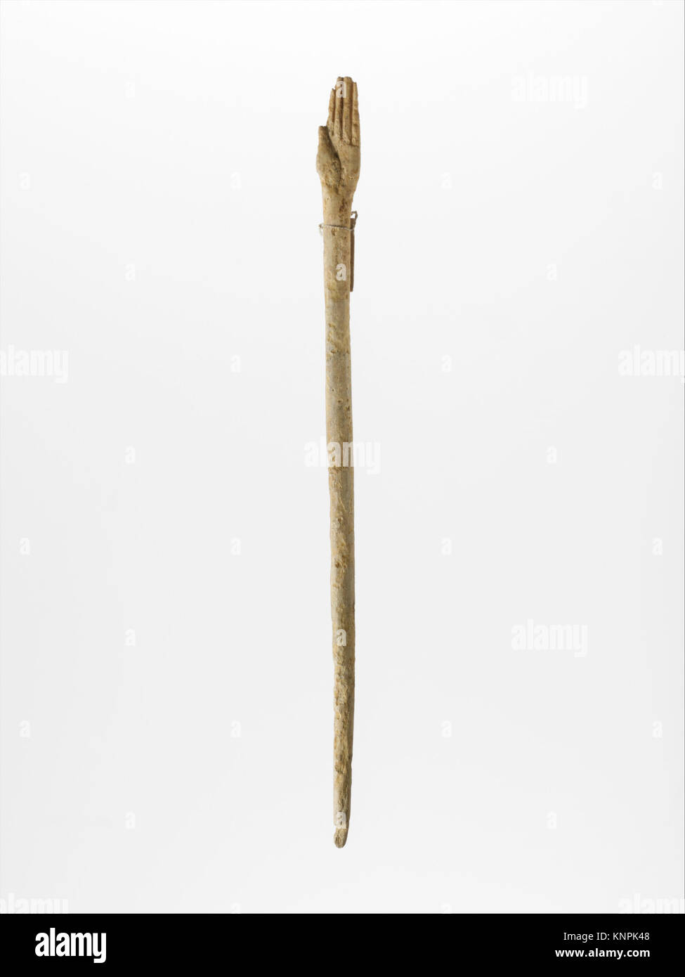 An ancient bone pin with a hand-shaped head, used as a fastener or ...