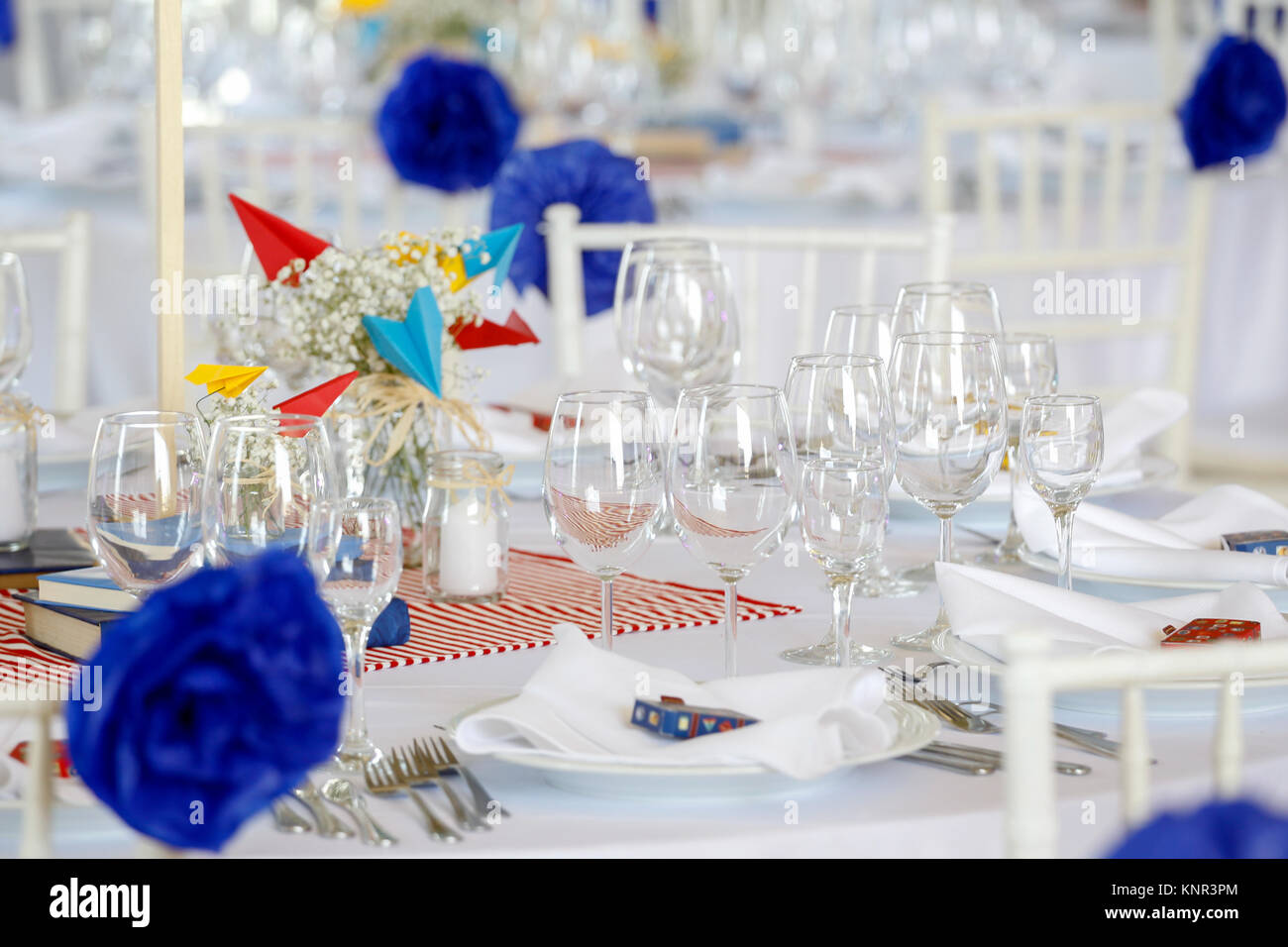 Circle dinner table served with white crockery and decorated with ...