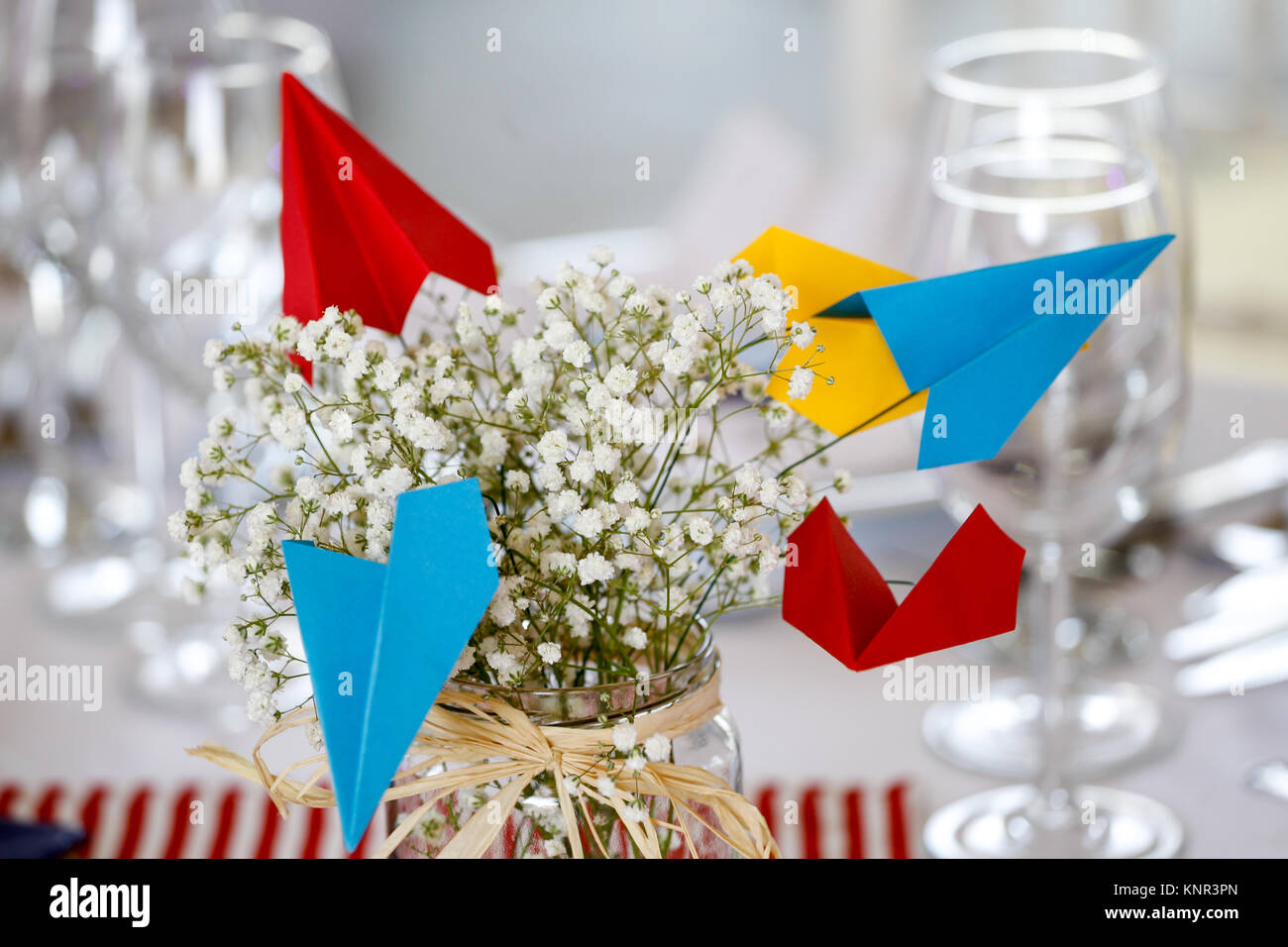 Circle dinner table served with white crockery and decorated with ...
