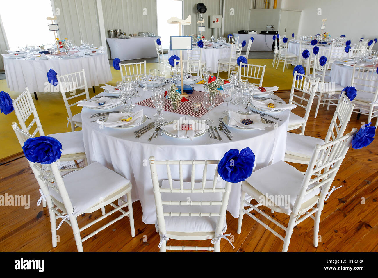 Circle dinner table served with white crockery and decorated with ...