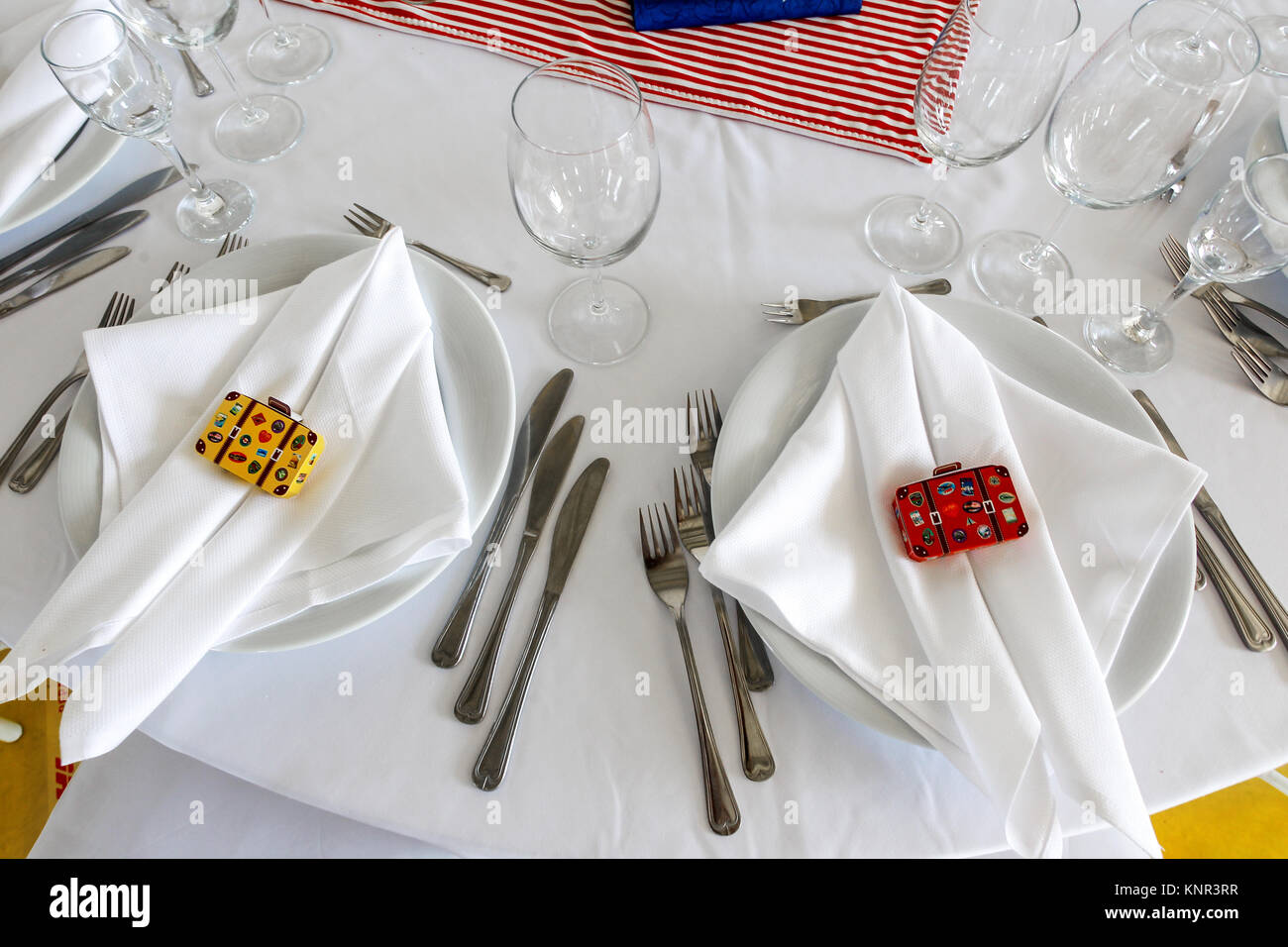 Circle dinner table served with white crockery and decorated with ...