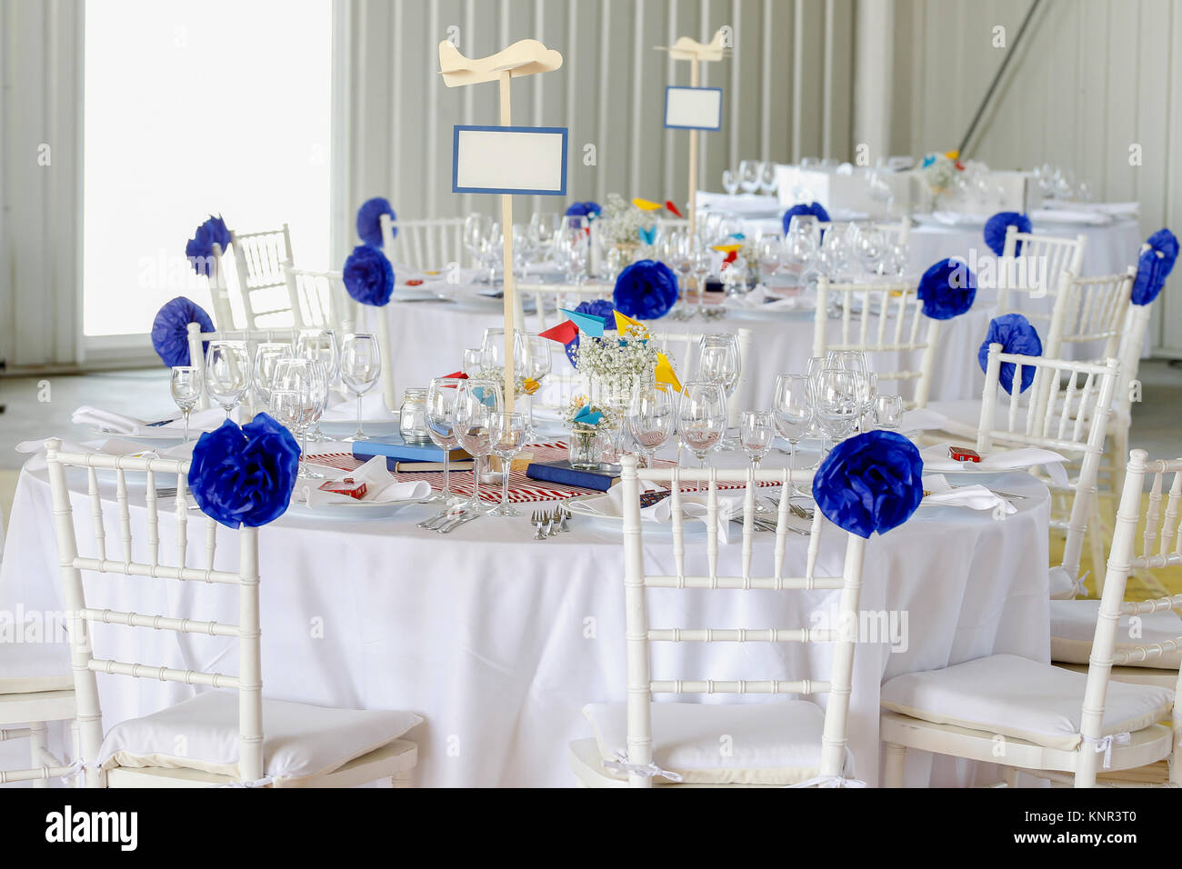 Circle dinner table served with white crockery and decorated with ...