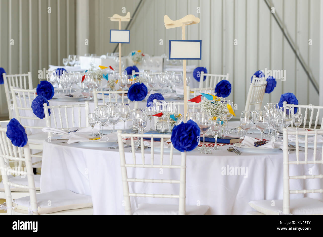 Circle dinner table served with white crockery and decorated with ...