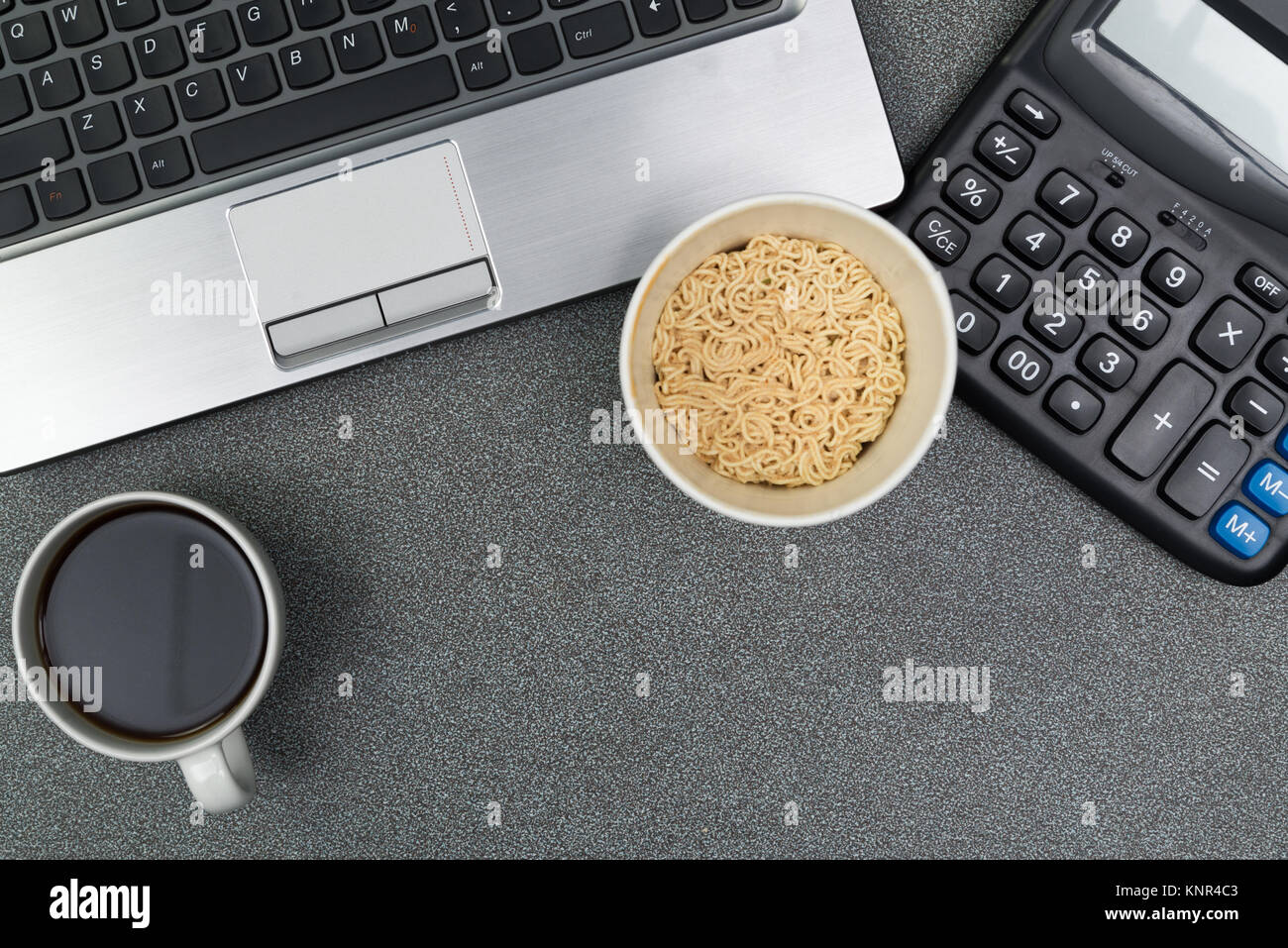 Laptop computer or notebook, calculator and cup of coffee, cup noodle ...