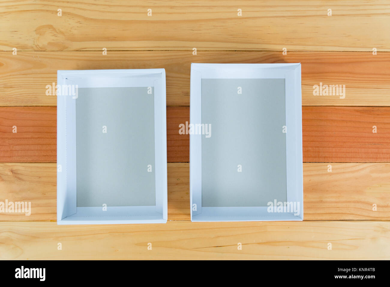 Top view of empty white gift box for mock up on bright wooden table ...