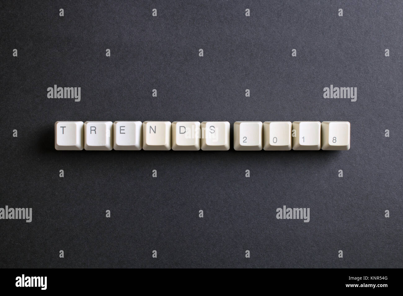 Trends 2018. Flat lay view from above on the table with computer keyboard keys buttons on a dark ...