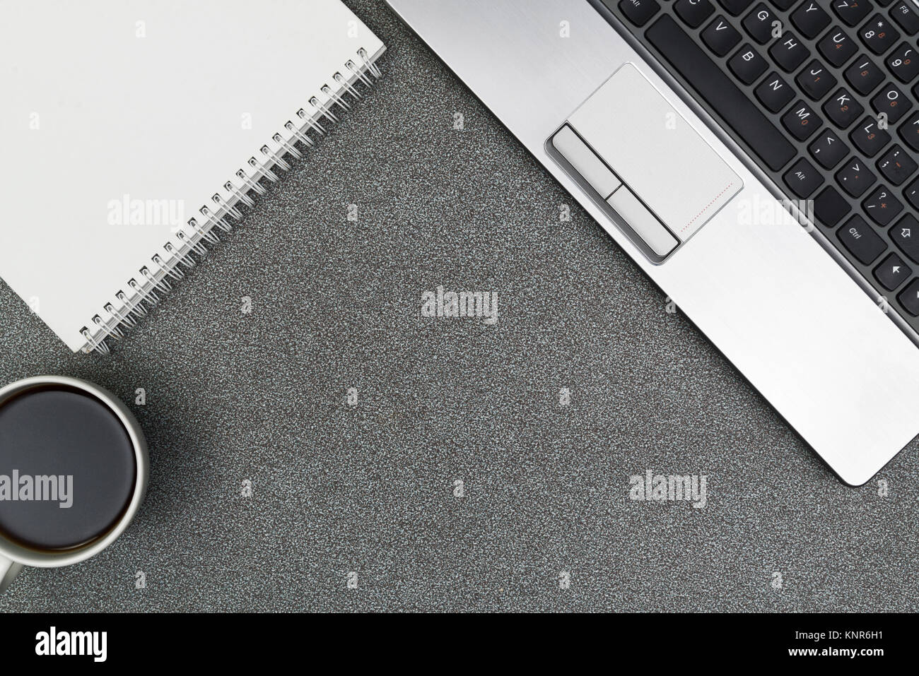 Laptop computer or notebook, note and cup of coffee on gray color ...