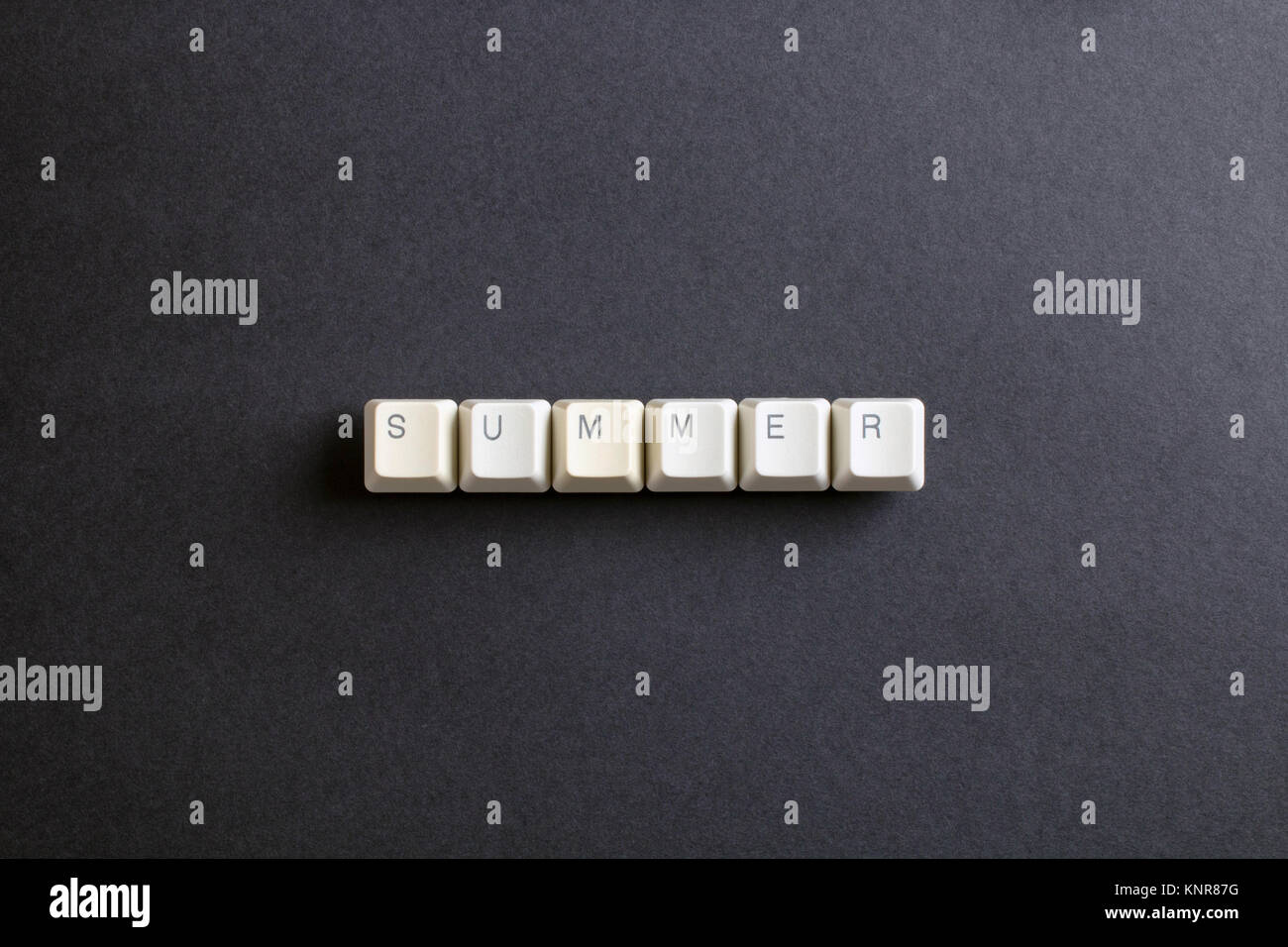 Summer word is written with computer keys button. Flat lay view from above on the table with ...