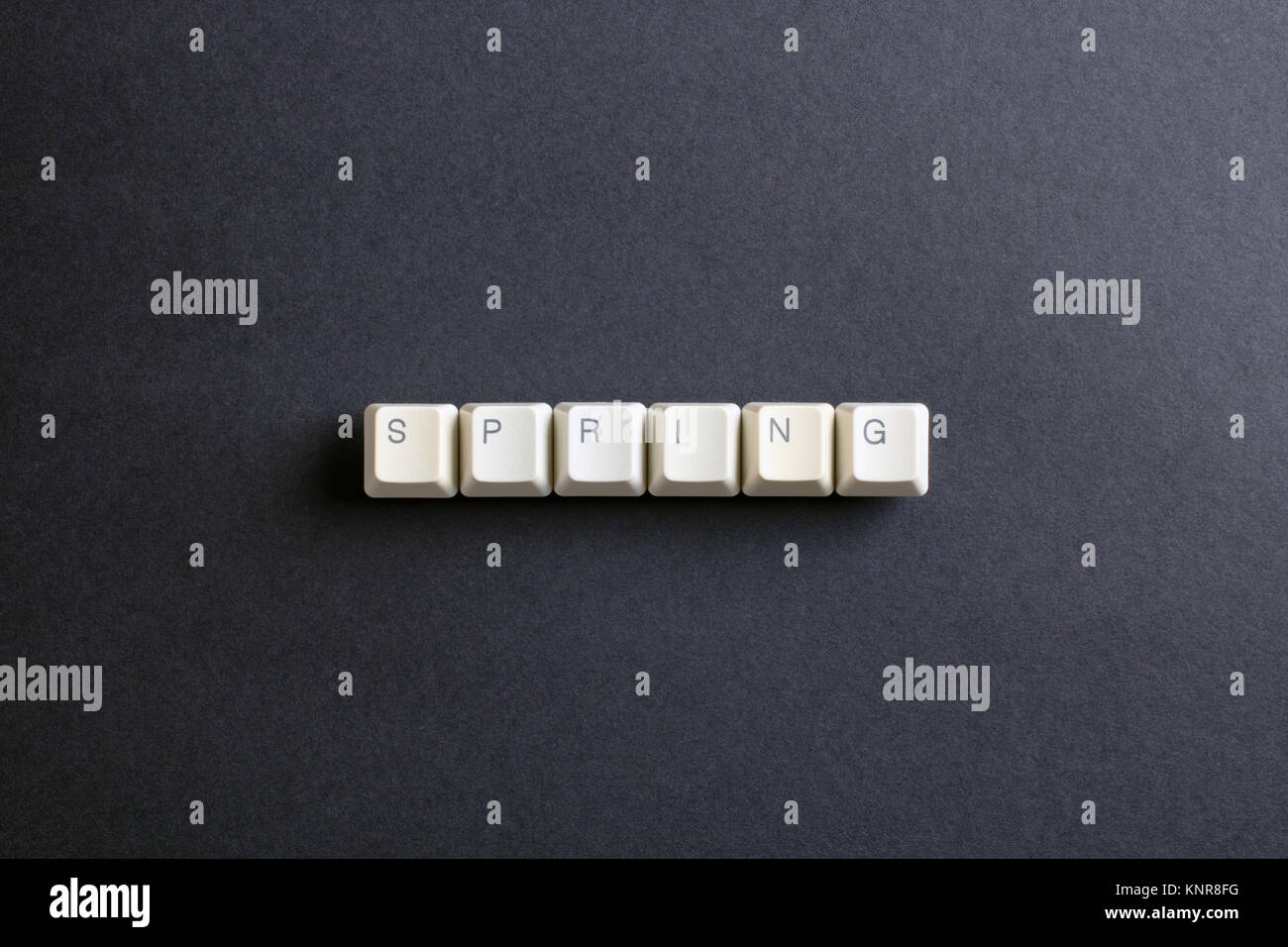 Spring word is written with computer keys button. Flat lay view from above on the table with ...
