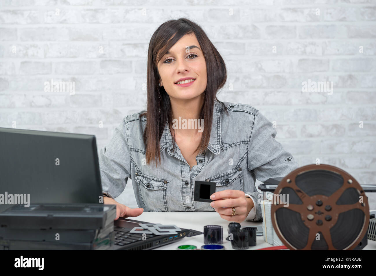 a young brunette woman looking at film slide Stock Photo - Alamy