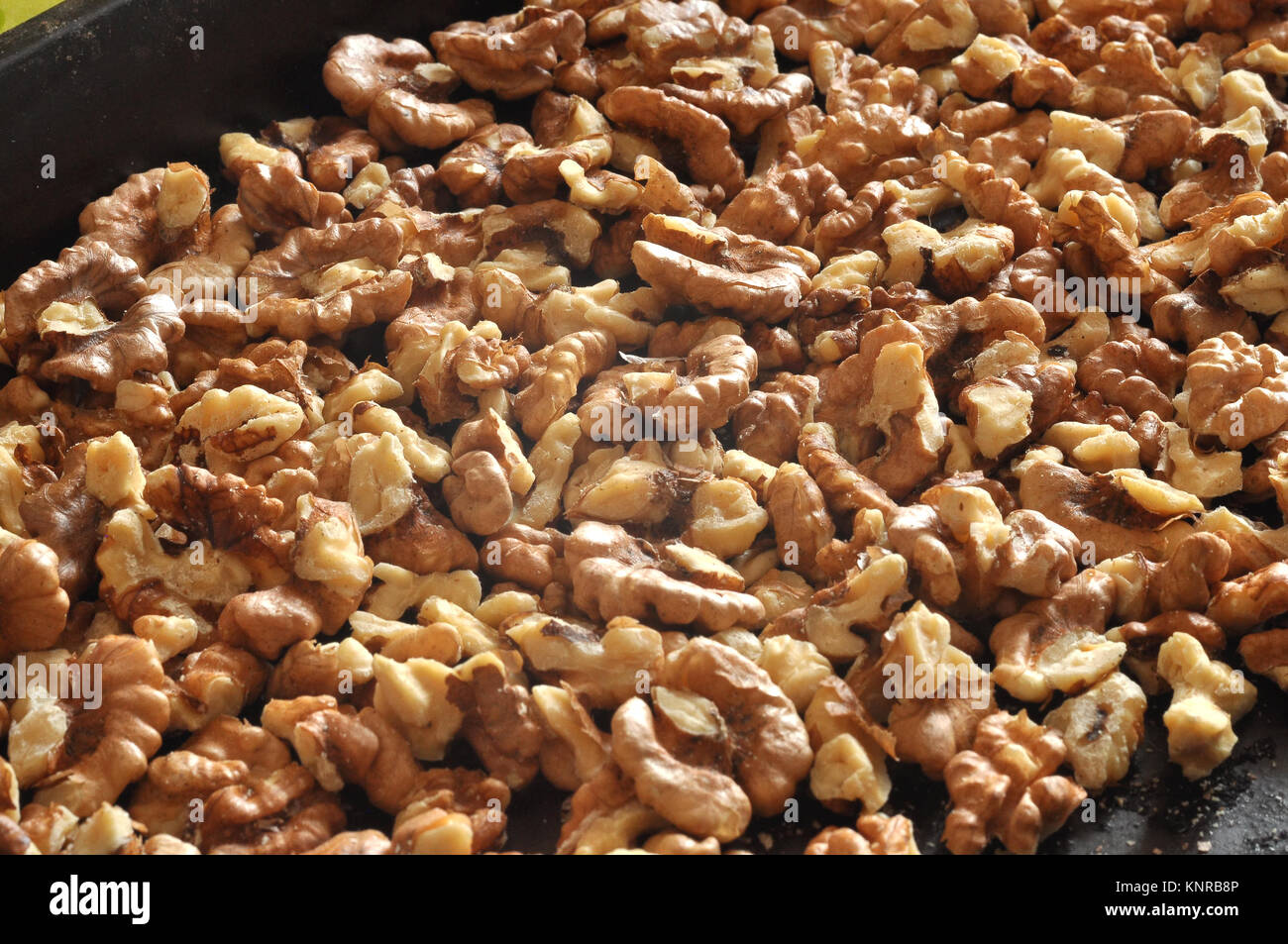 Baked walnut kernels on a black backing tray close-up. Walnut ...
