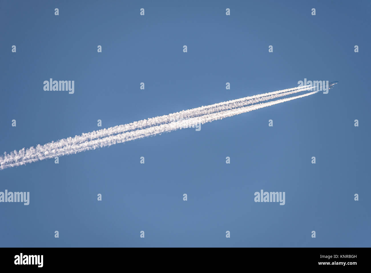 Contrails. Jet airliner plane flying at altitude leaving contrail ...