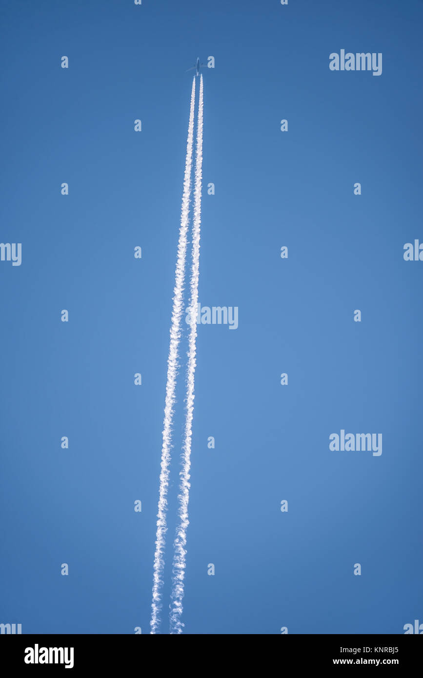 Contrails. Contrail. Jet airliner plane flying at altitude leaving ...