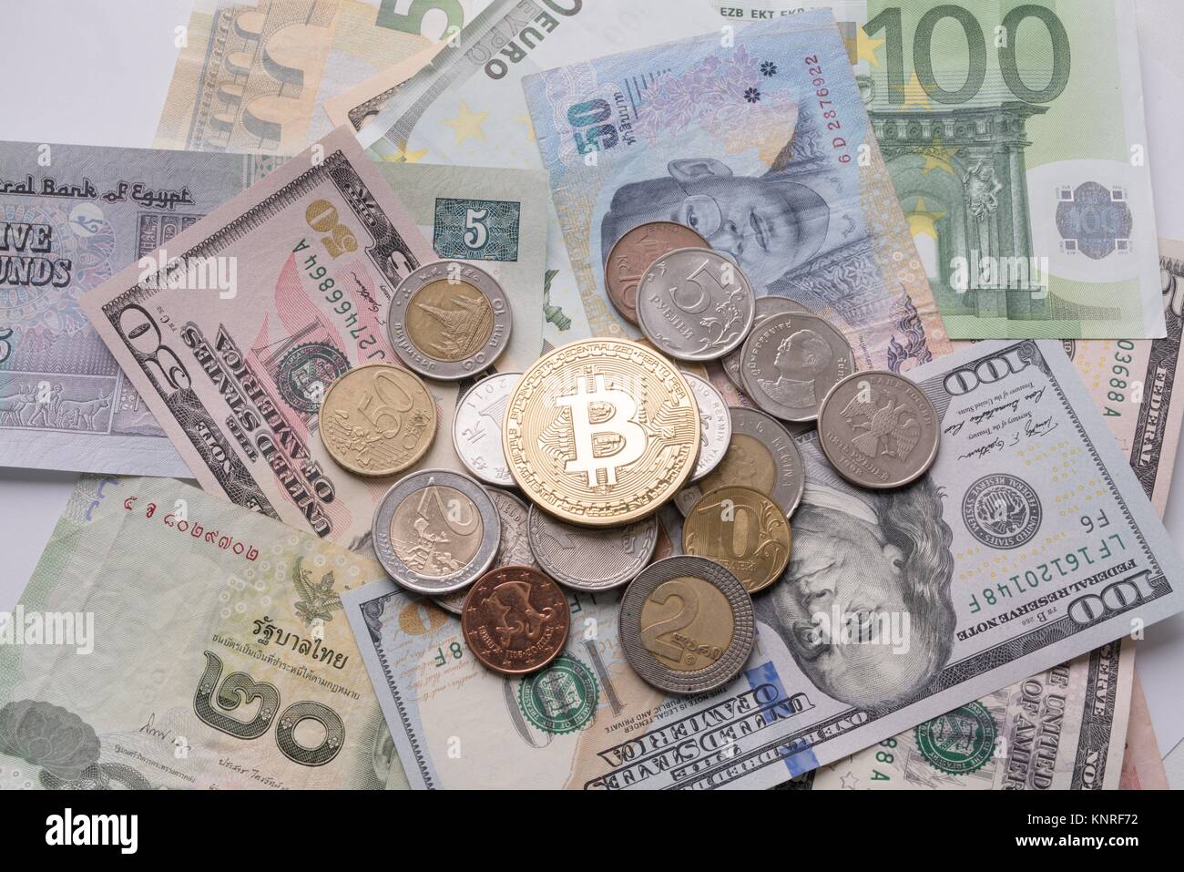 Bitcoin on bills and coins of different countries Stock Photo - Alamy