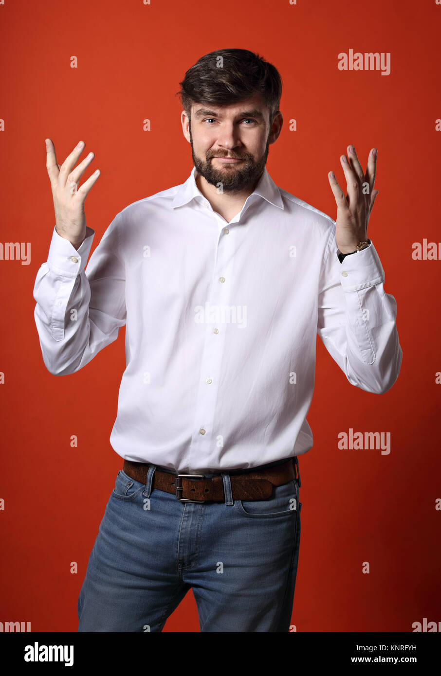 Confused puzzled funny bearded man in white shirt and blue jeans ...