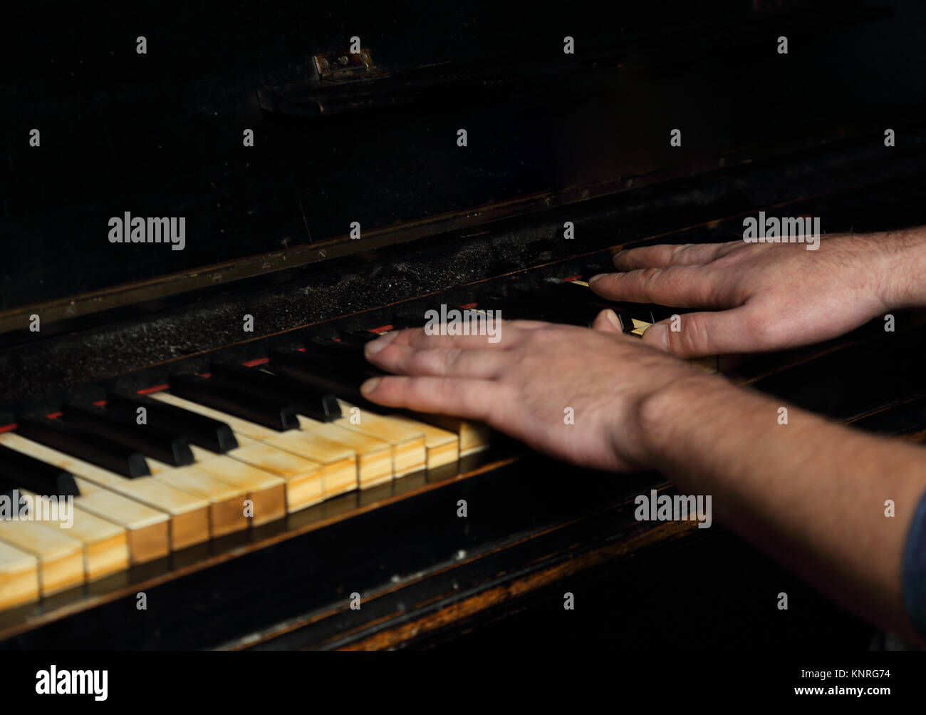 Old vintage classical black piano with male hand playing on it in ...
