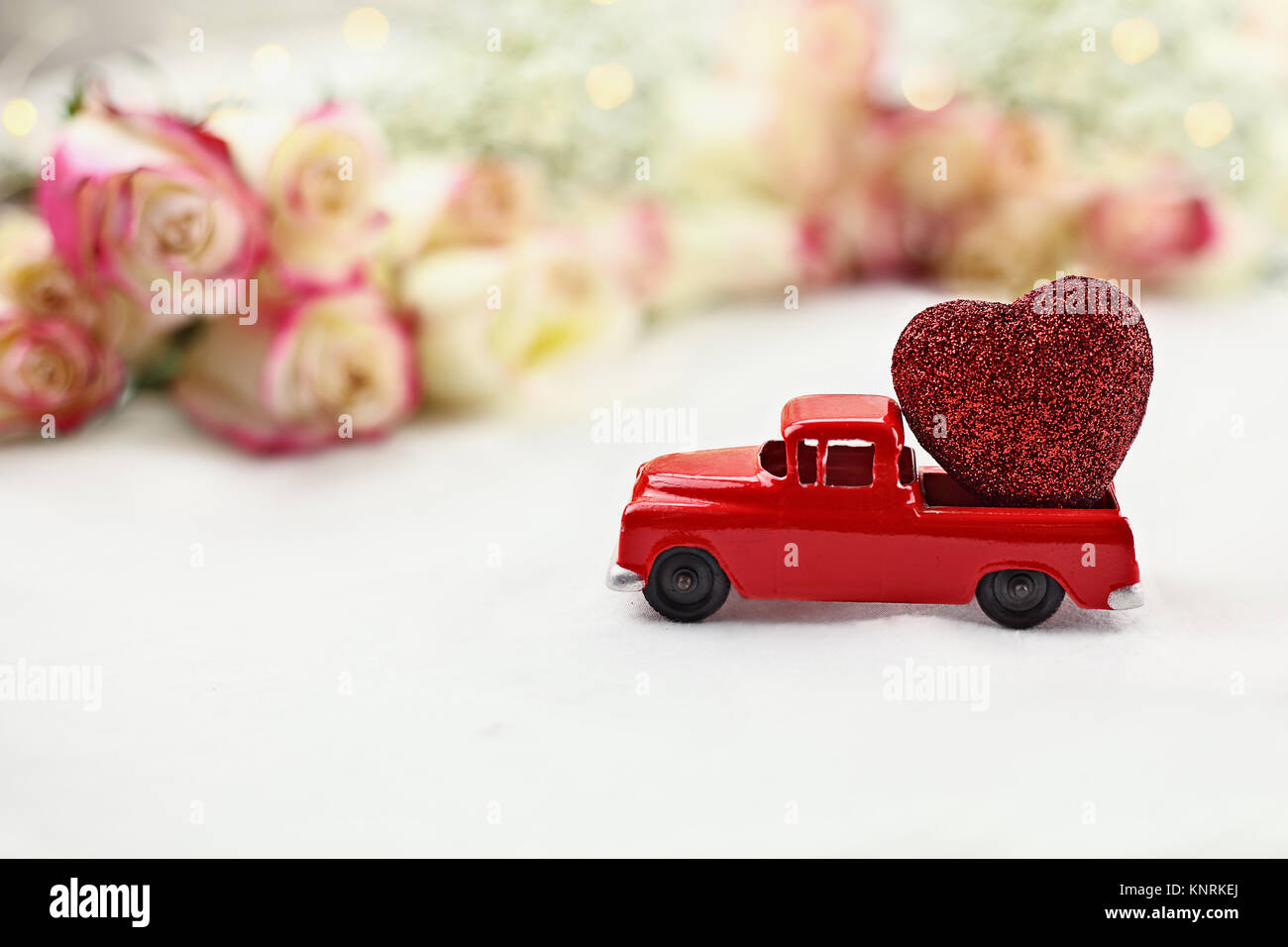 1950's antique vintage red truck hauling a glittery red heart past a ...