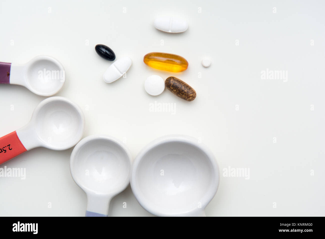 Medicine pills and tablets with spoons to measure medicine dose ...