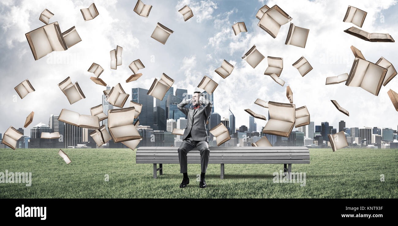 Many old books falling from above and student guy sitting on ben Stock ...