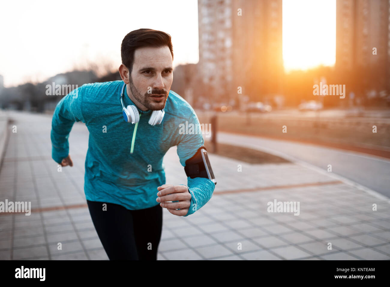 Handsome runner exercising by running in city Stock Photo - Alamy