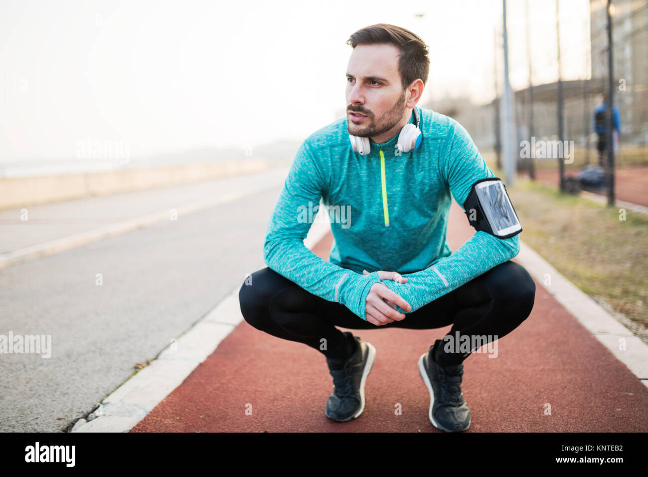 Sporty handsome man resting after jogging Stock Photo - Alamy