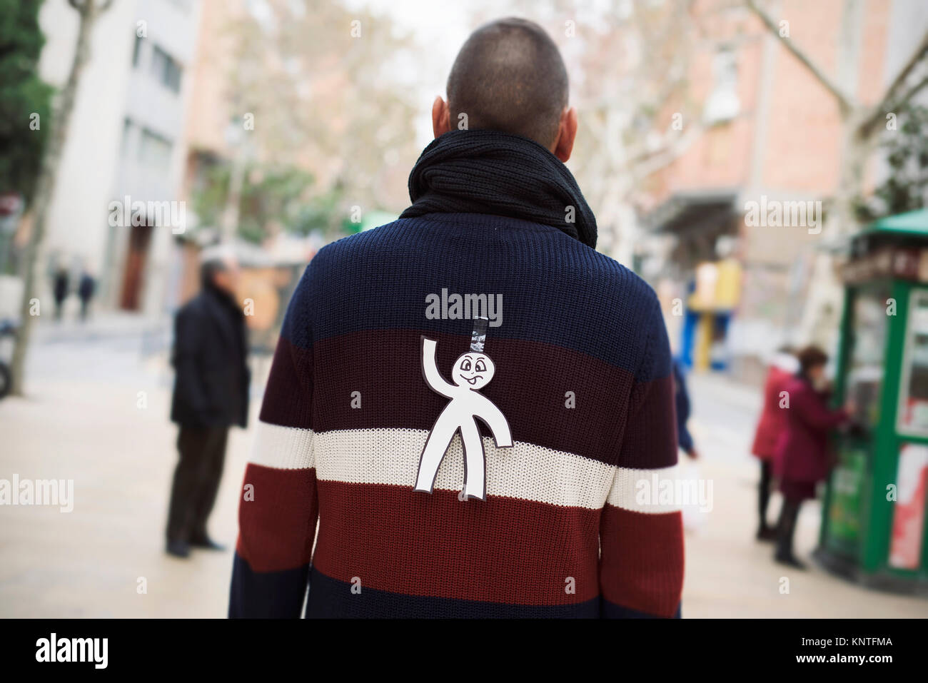 young man in the street with a paper man in his back as a prank for the ...