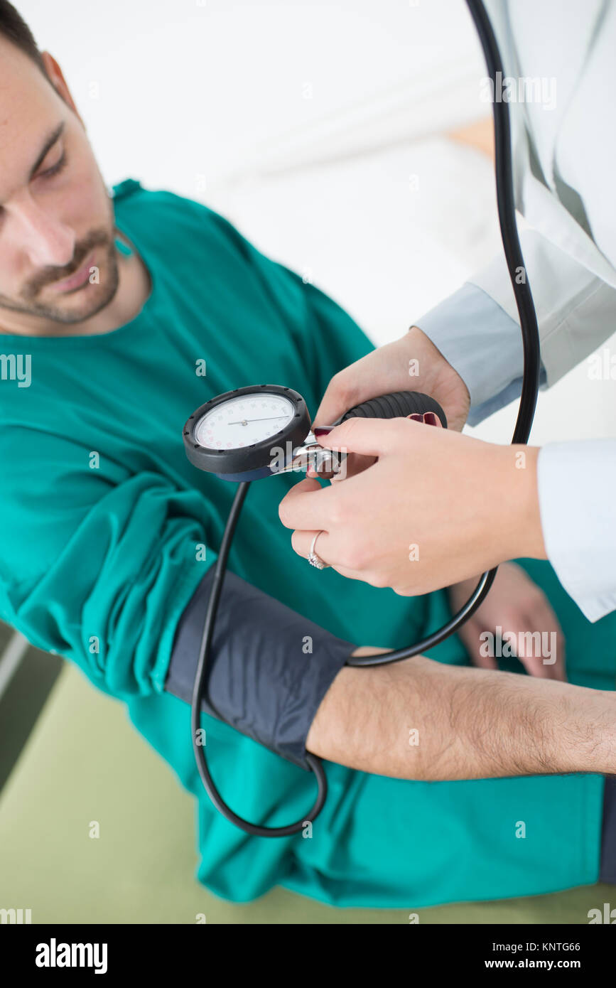Female doctor checking blood pressure of a patient at clinic Stock ...