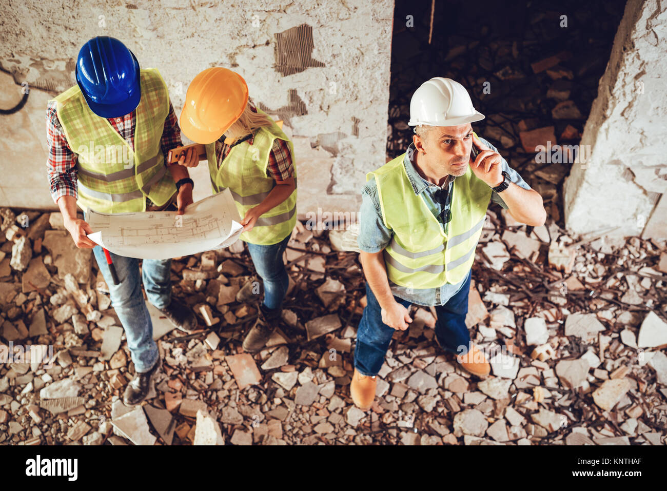 Construction architects using phone in building damaged in the disaster ...